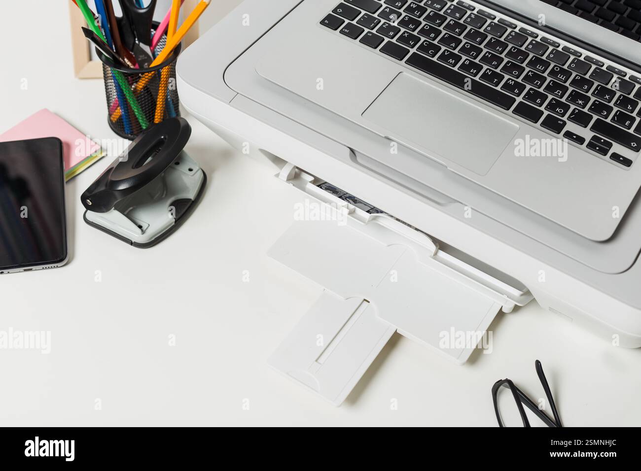Workstation setup with laptop, printer, and office supplies for ...