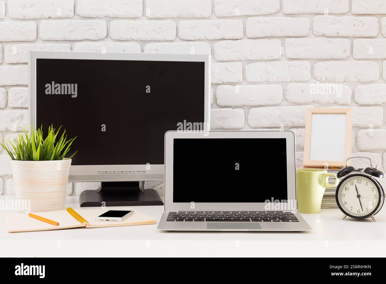 Modern workspace setup featuring a laptop, desktop monitor, and desk ...