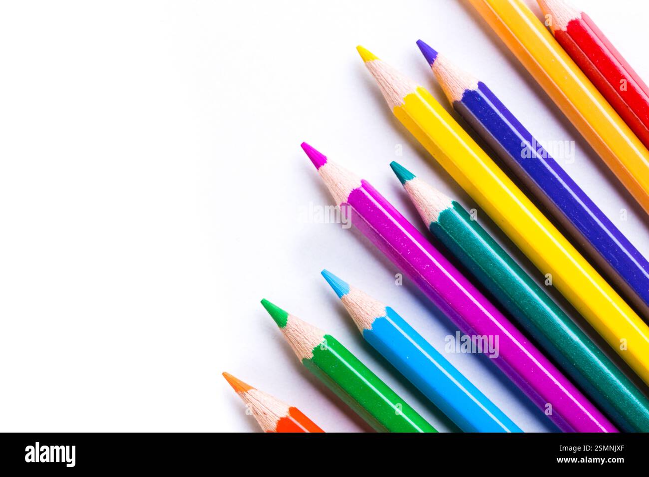 Colorful pencils arranged in a neat line on a white background ...