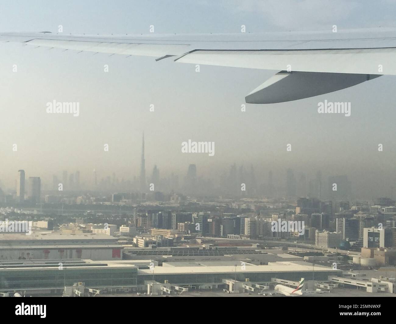 A glimpse of Dubai's urban sprawl unfolds beneath the airplane wing, a ...