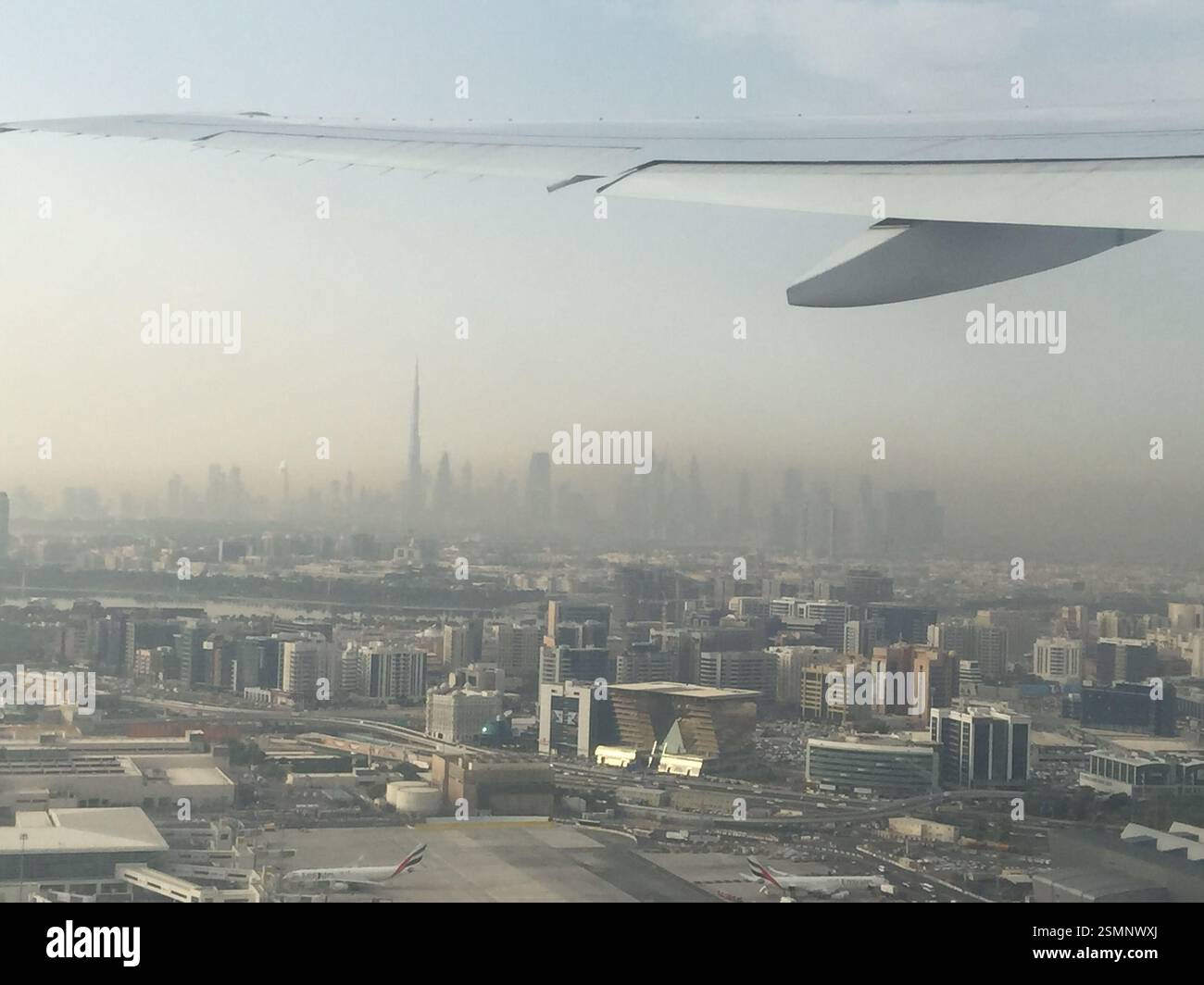 A glimpse of Dubai unfolds beneath the airplane wing. The city sprawls ...