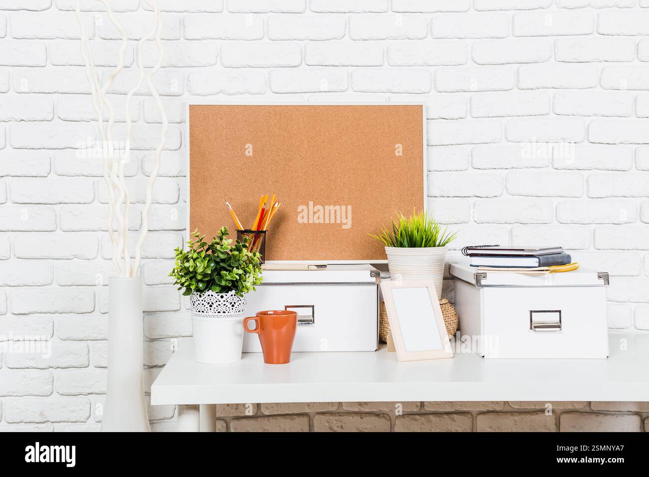 Decorative workspace setup featuring corkboard, plants, and storage ...