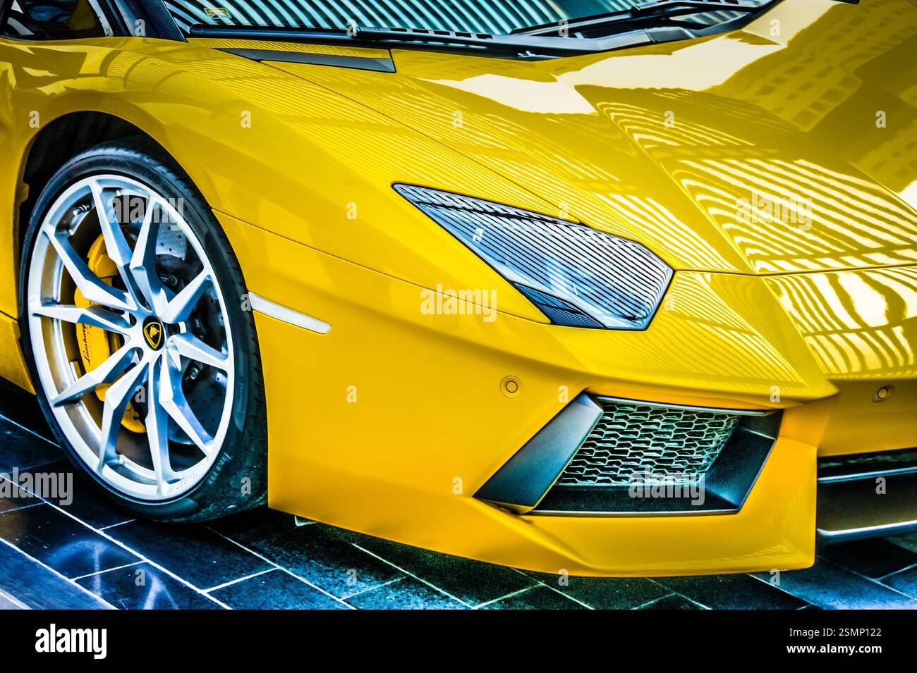 A gleaming showroom floor reflects the vibrant yellow paint of a sleek ...