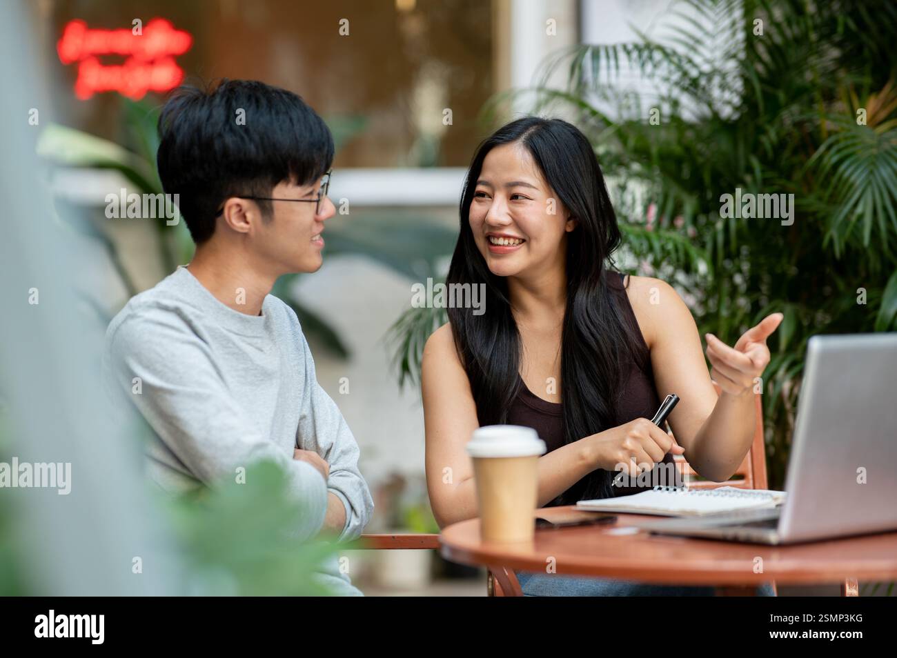 A cheerful, beautiful Asian woman enjoys sharing her ideas with her ...