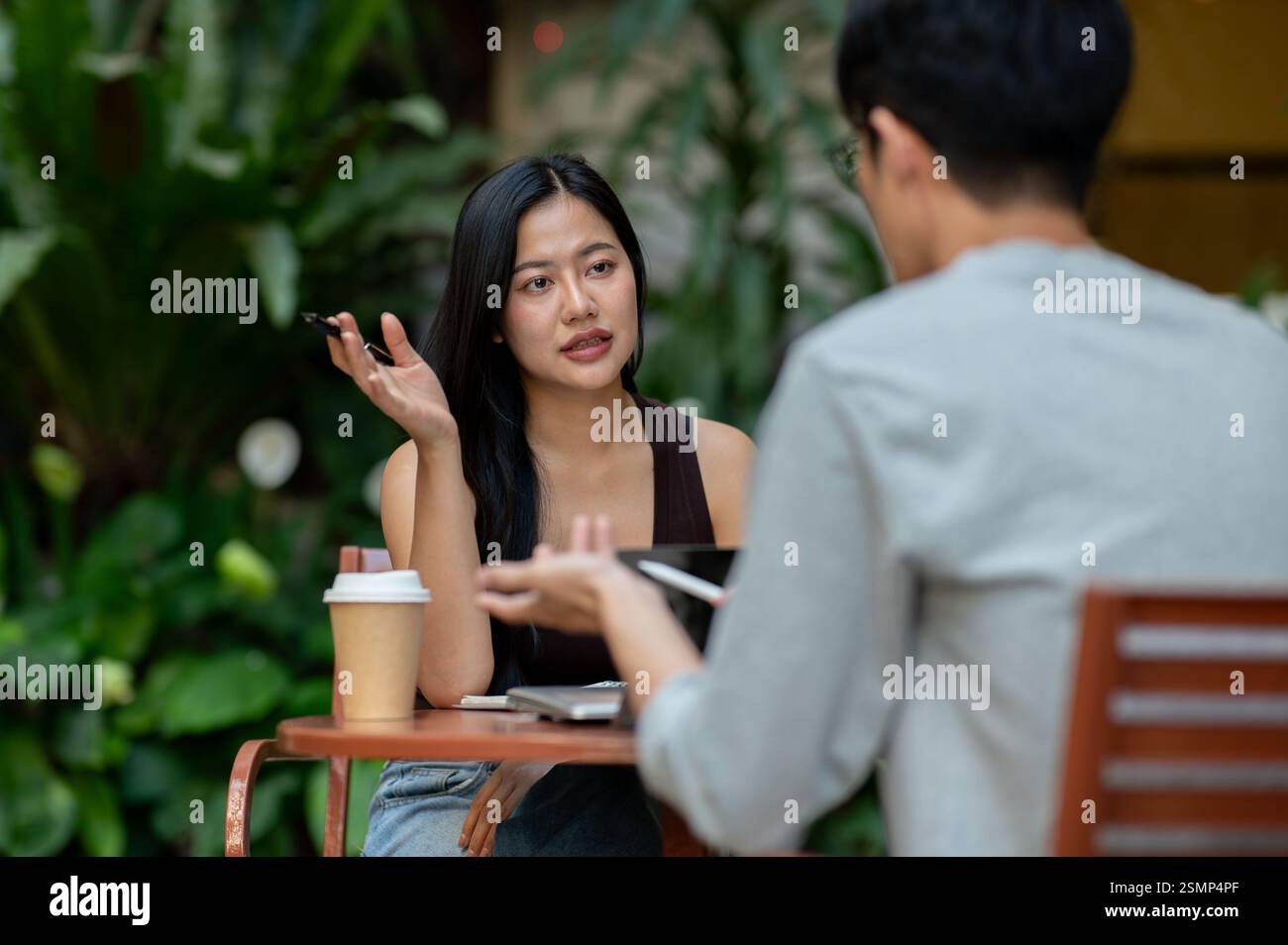 A gorgeous, confident Asian woman having an informal meeting with her ...