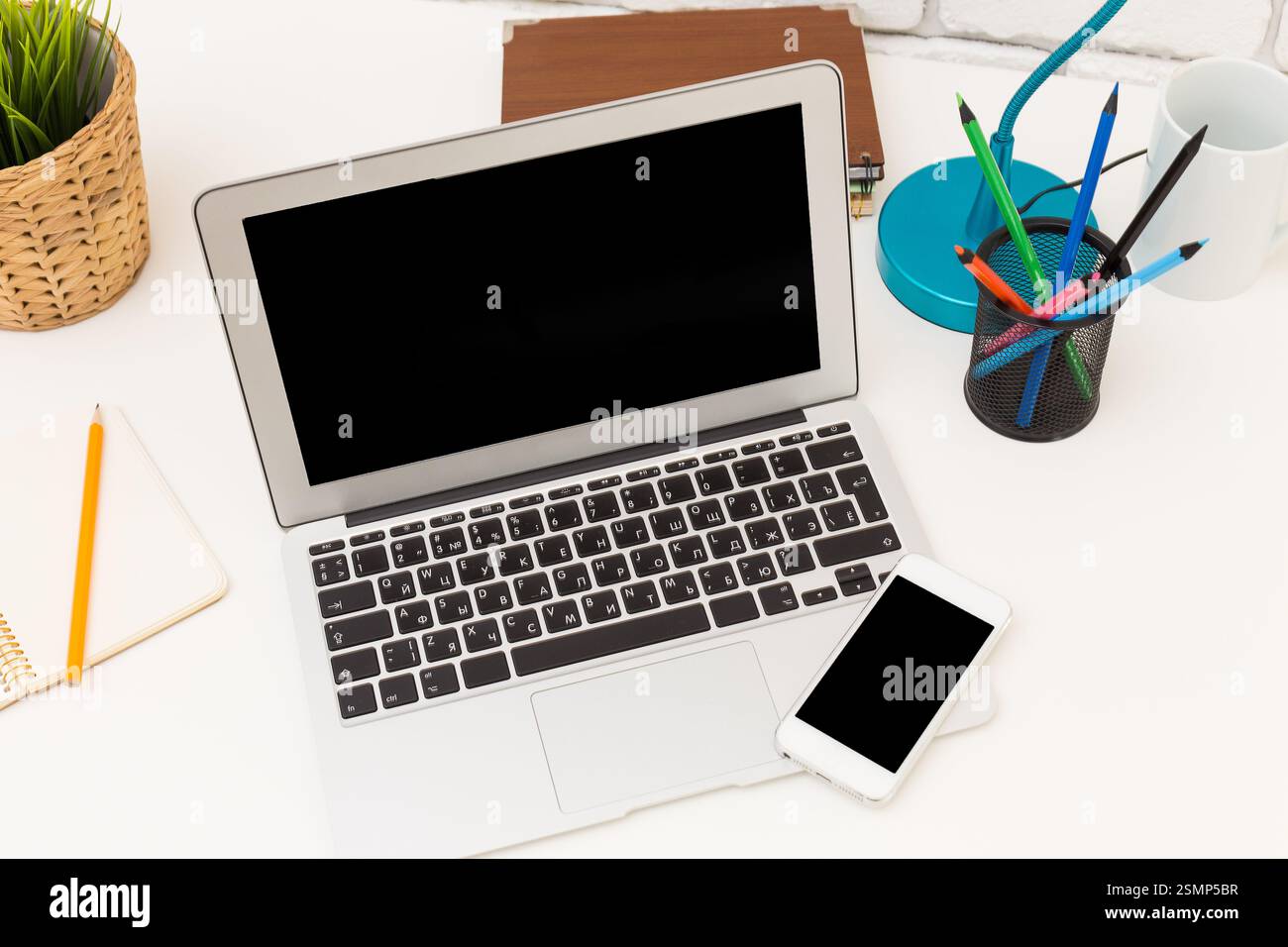 Modern workspace with laptop, smartphone, and office supplies on ...