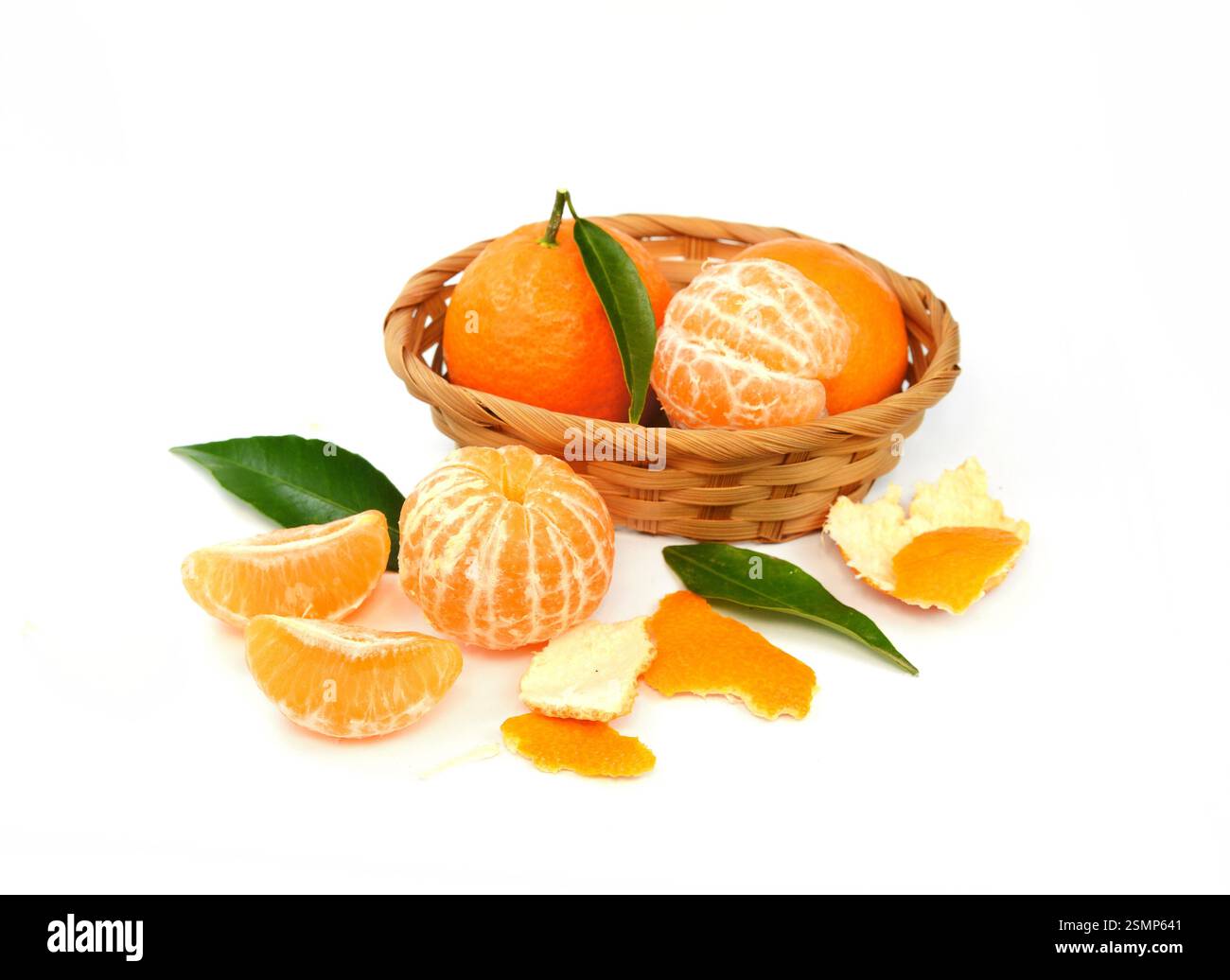 peeled and unpeeled tangerines in a basket isolated on white ...