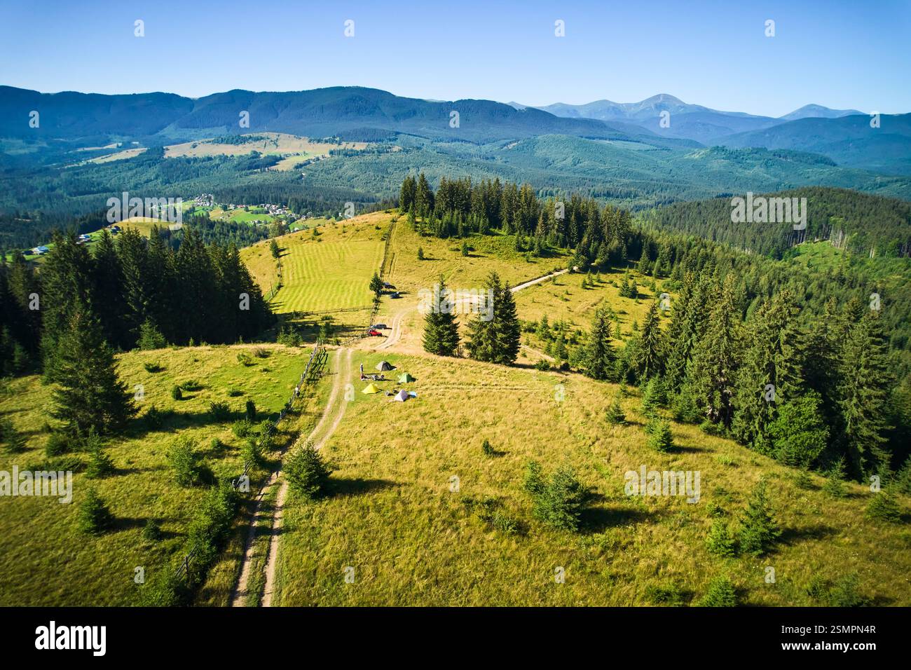 Aerial view campsite in mountains, with several colorful tents on ...