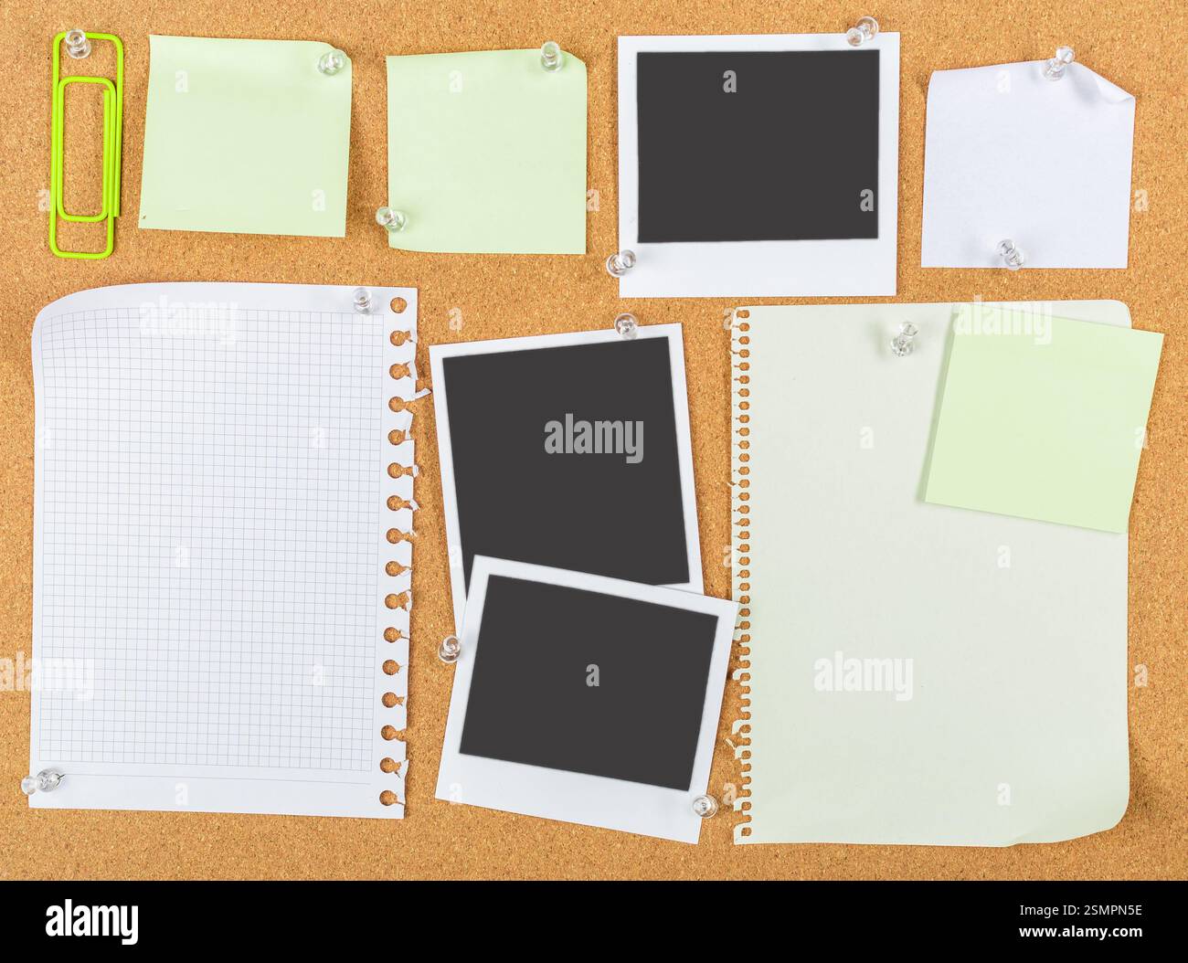 Collection of blank sticky notes and empty photo frames on a corkboard ...