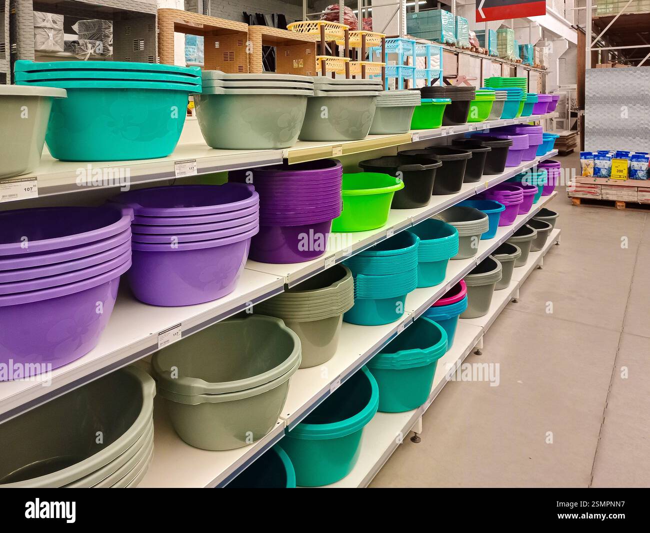 Colorful plastic buckets, basins, and stools neatly arranged on store ...
