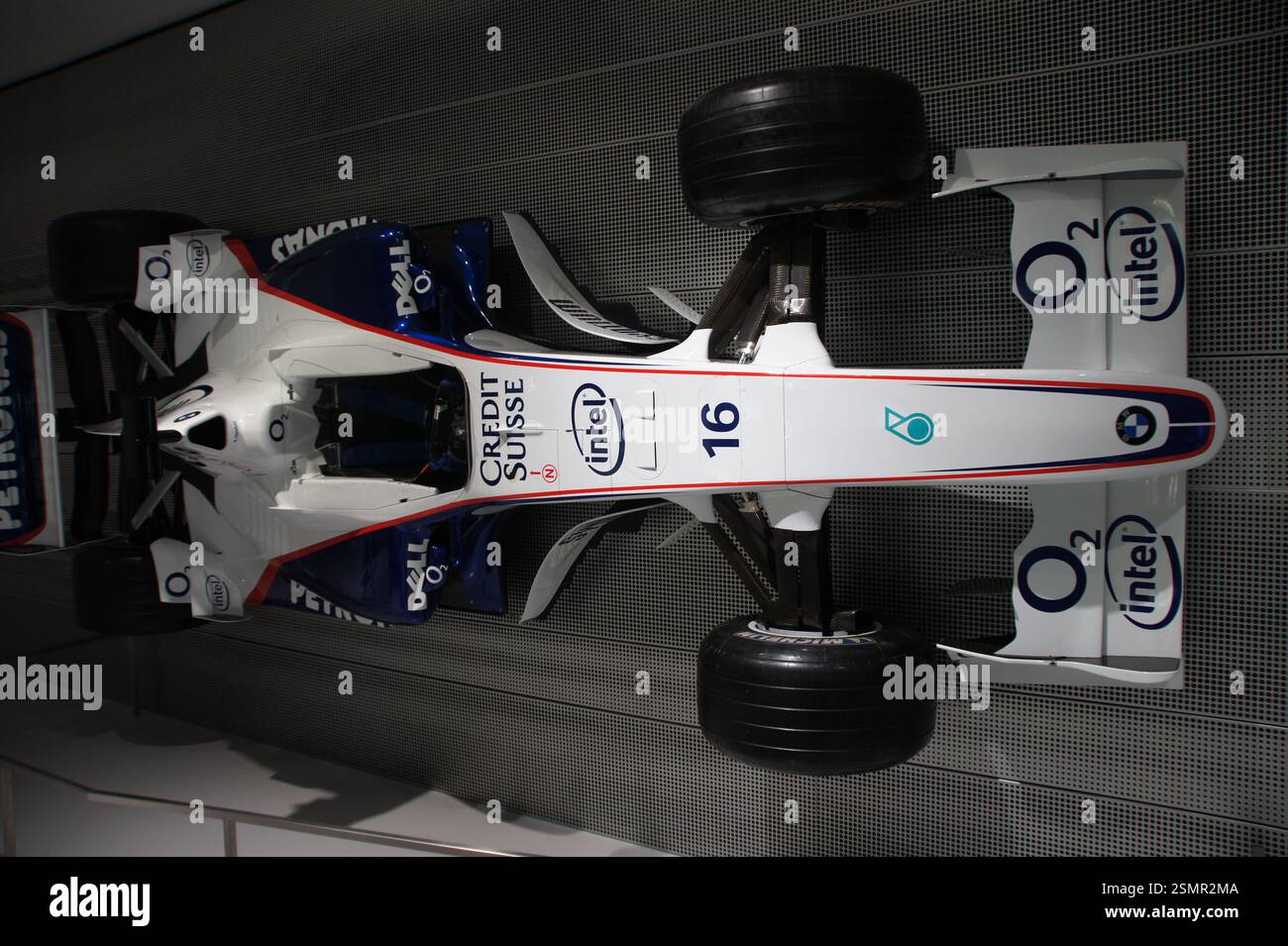 A white BMW Sauber F1.06 race car with a blue stripe streaks across the ...