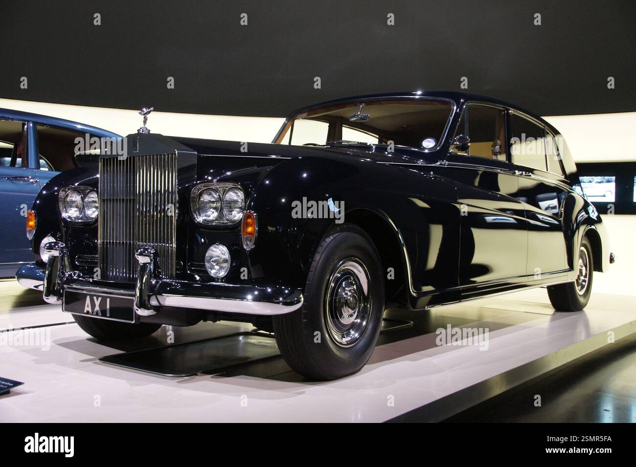 Germany, Munich. Two Rolls-Royce cars gleam under museum lights ...