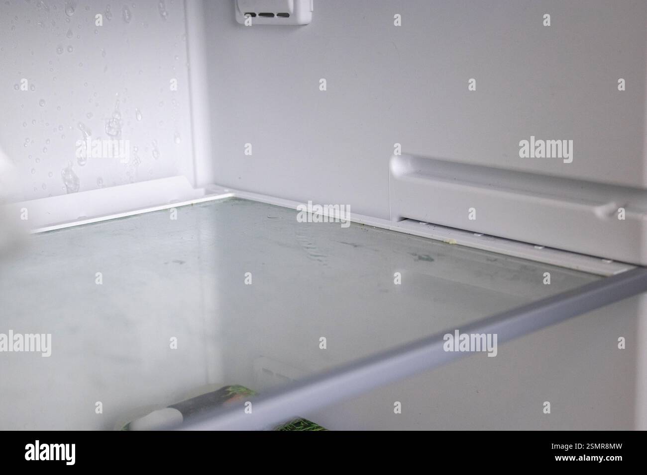 Close up of an open modern dirty refrigerator shelves that needs to be ...