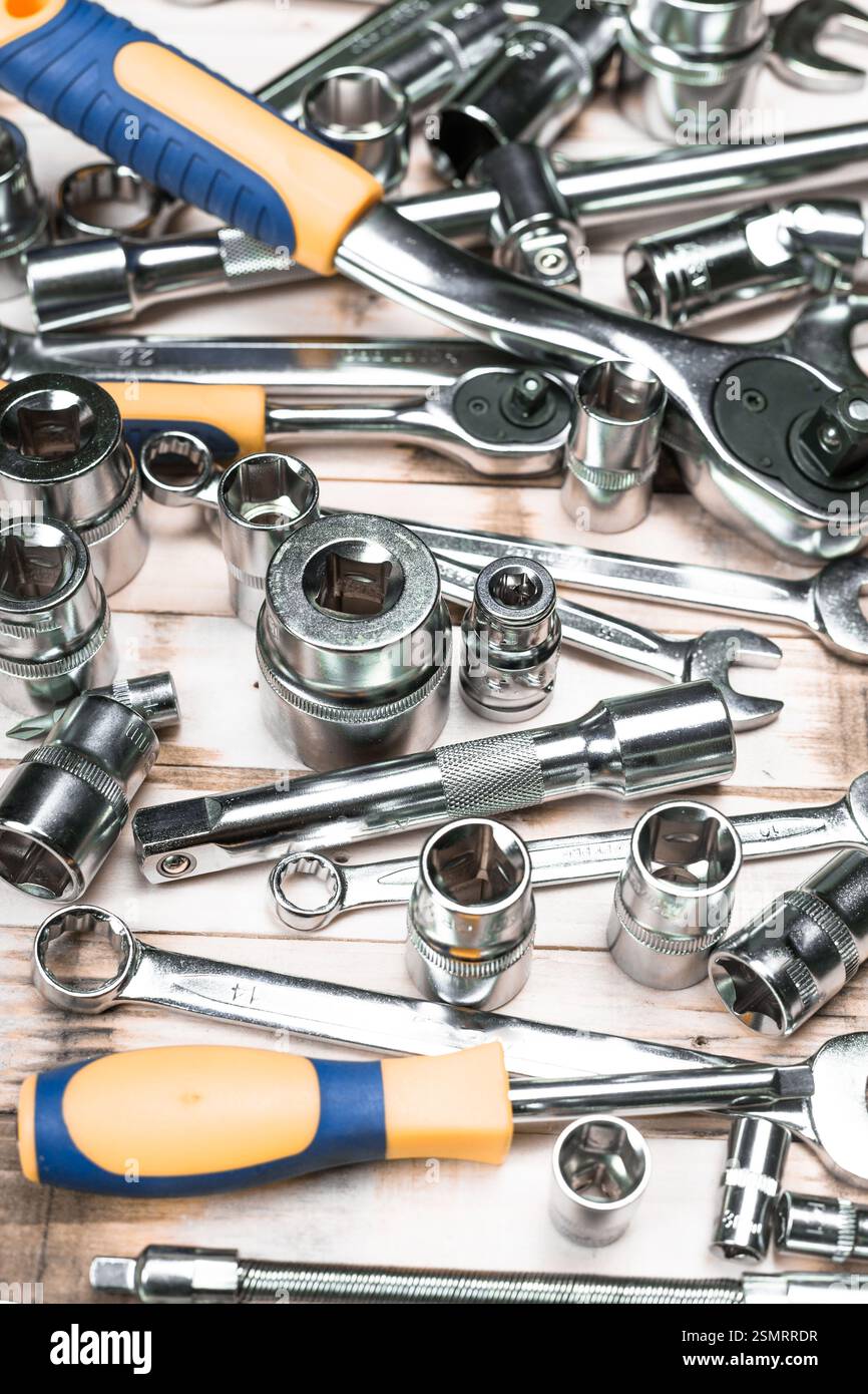 Collection of metallic tools scattered on wooden surface showcasing ...