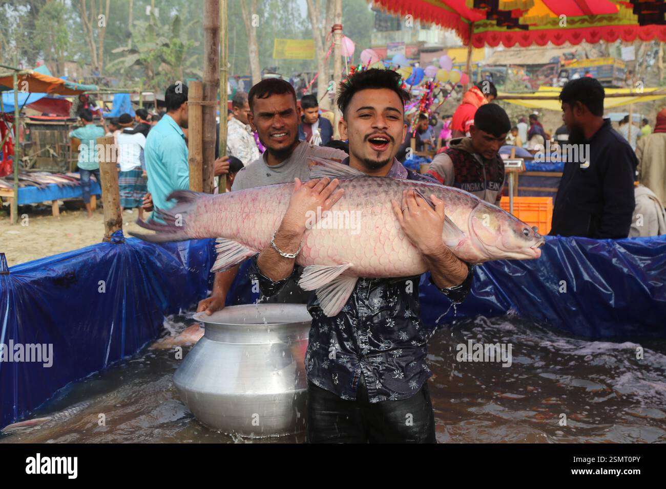 Bogura. 13th Feb, 2025. A man shows his big fish at a fish fair in ...