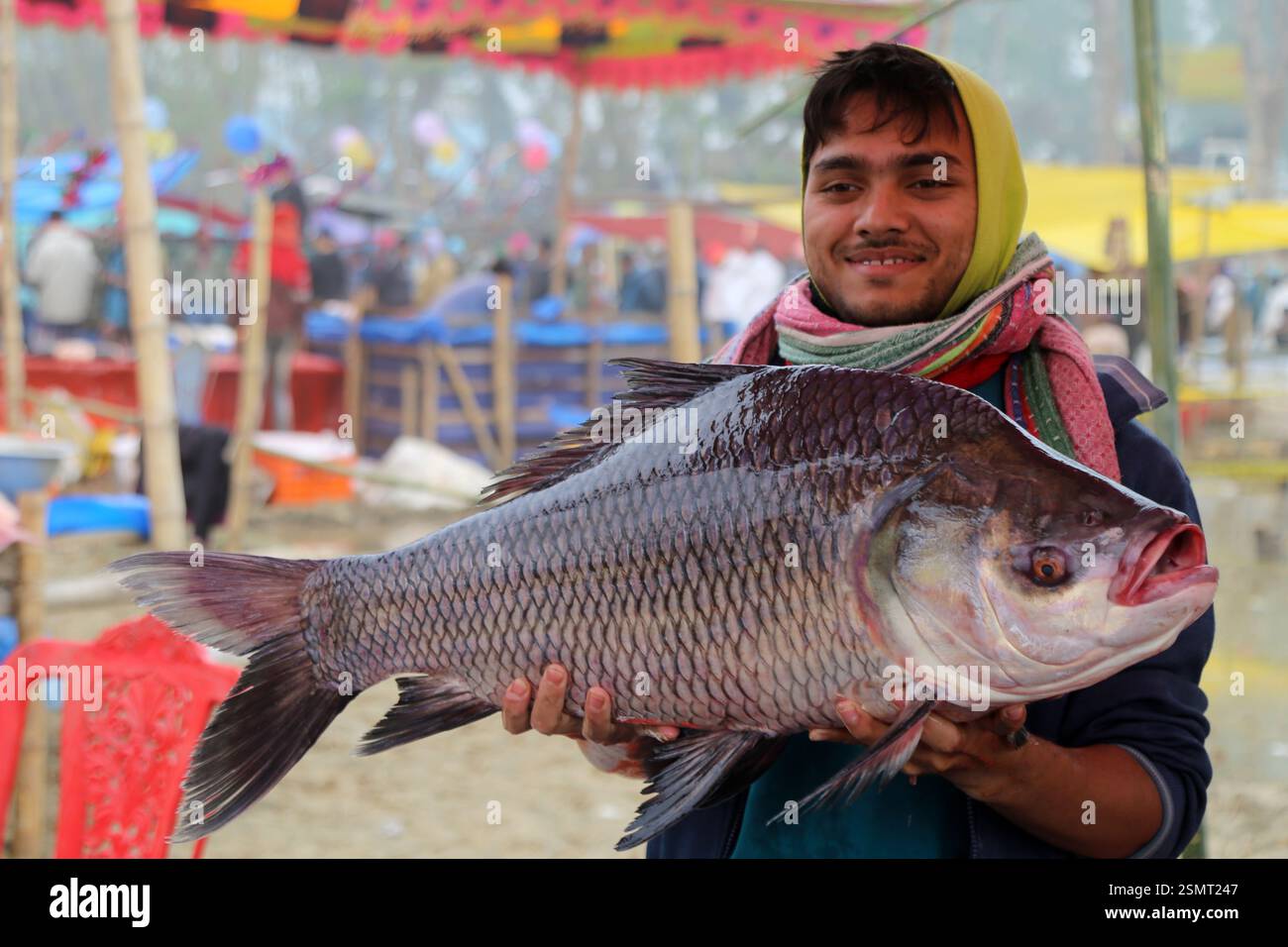 Bogura. 13th Feb, 2025. A man shows his big fish at a fish fair in ...