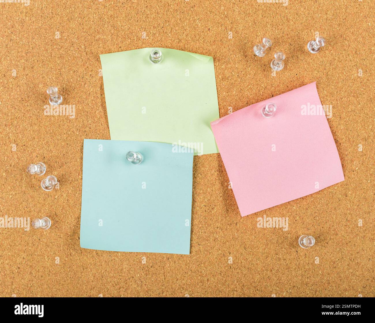 Colorful sticky notes pinned on corkboard with pushpins in an organized ...