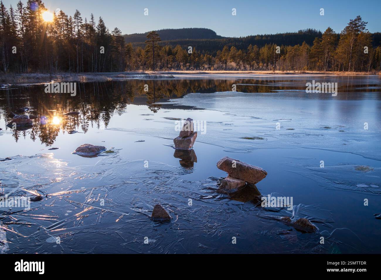 A frozen lake in Lunner Almenning, where stones rest encased in ice and ...