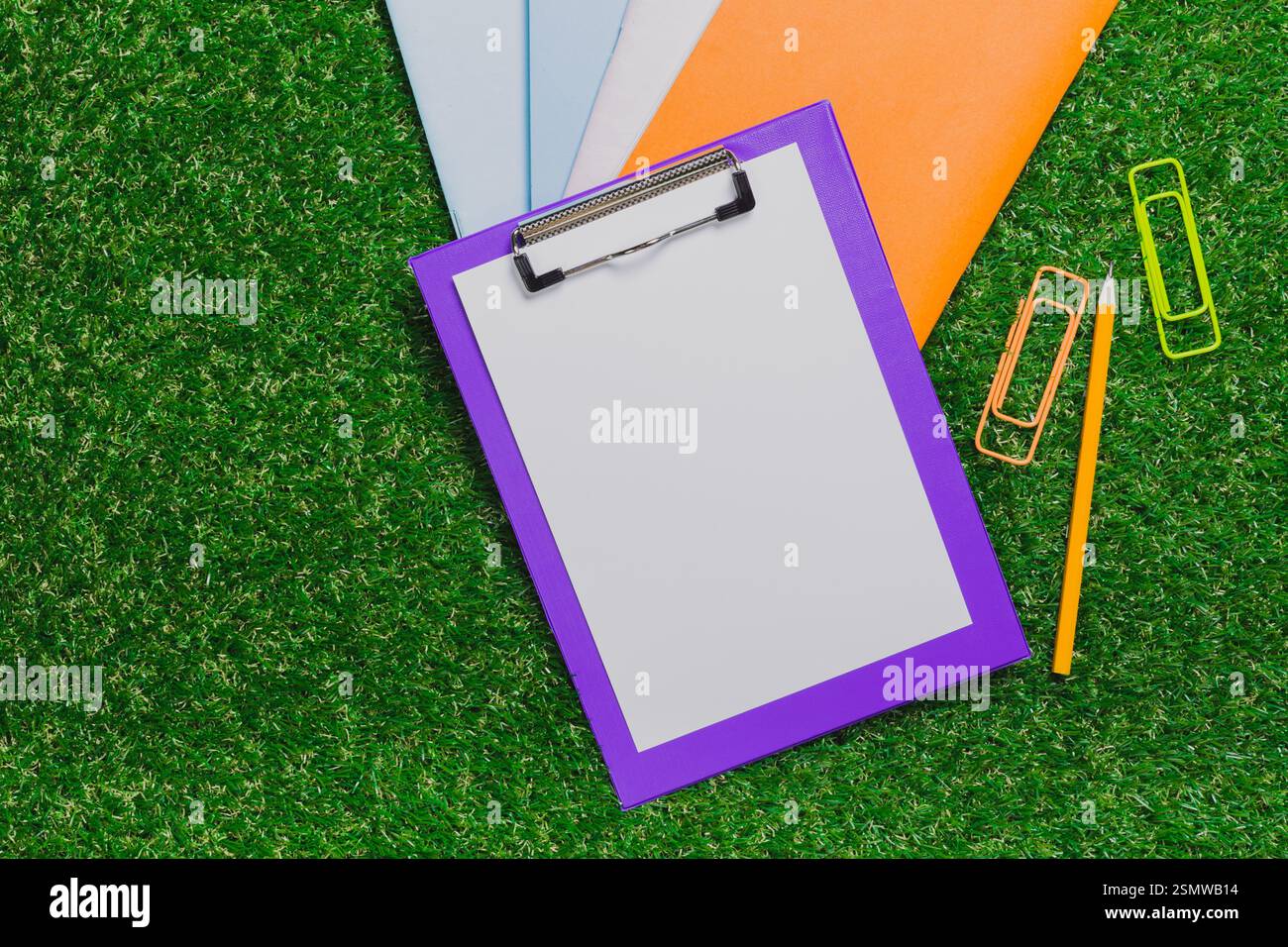 Colorful stationery supplies arranged on synthetic grass for a vibrant ...