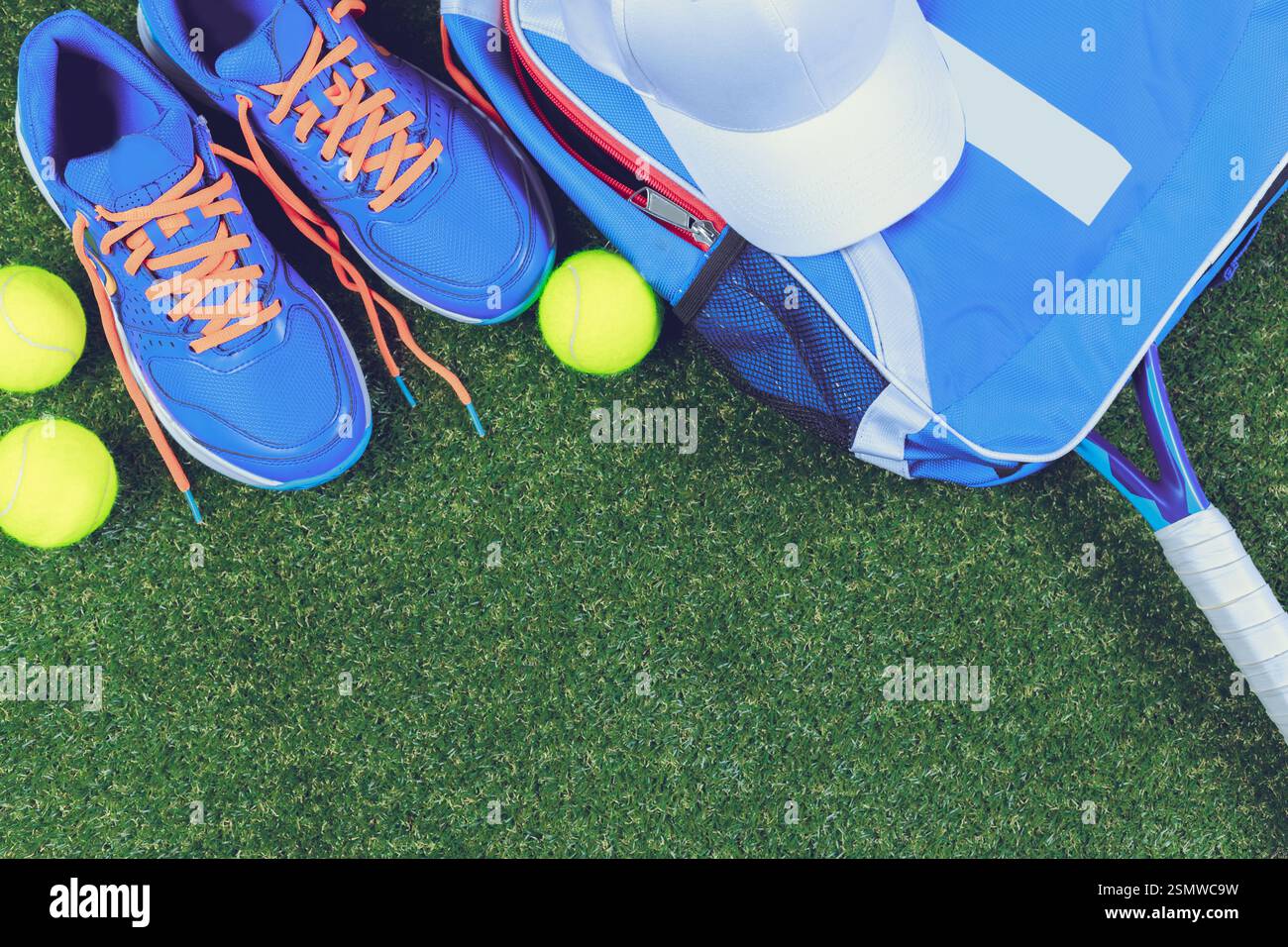 Bright blue tennis shoes and equipment ready for a game on green grass ...