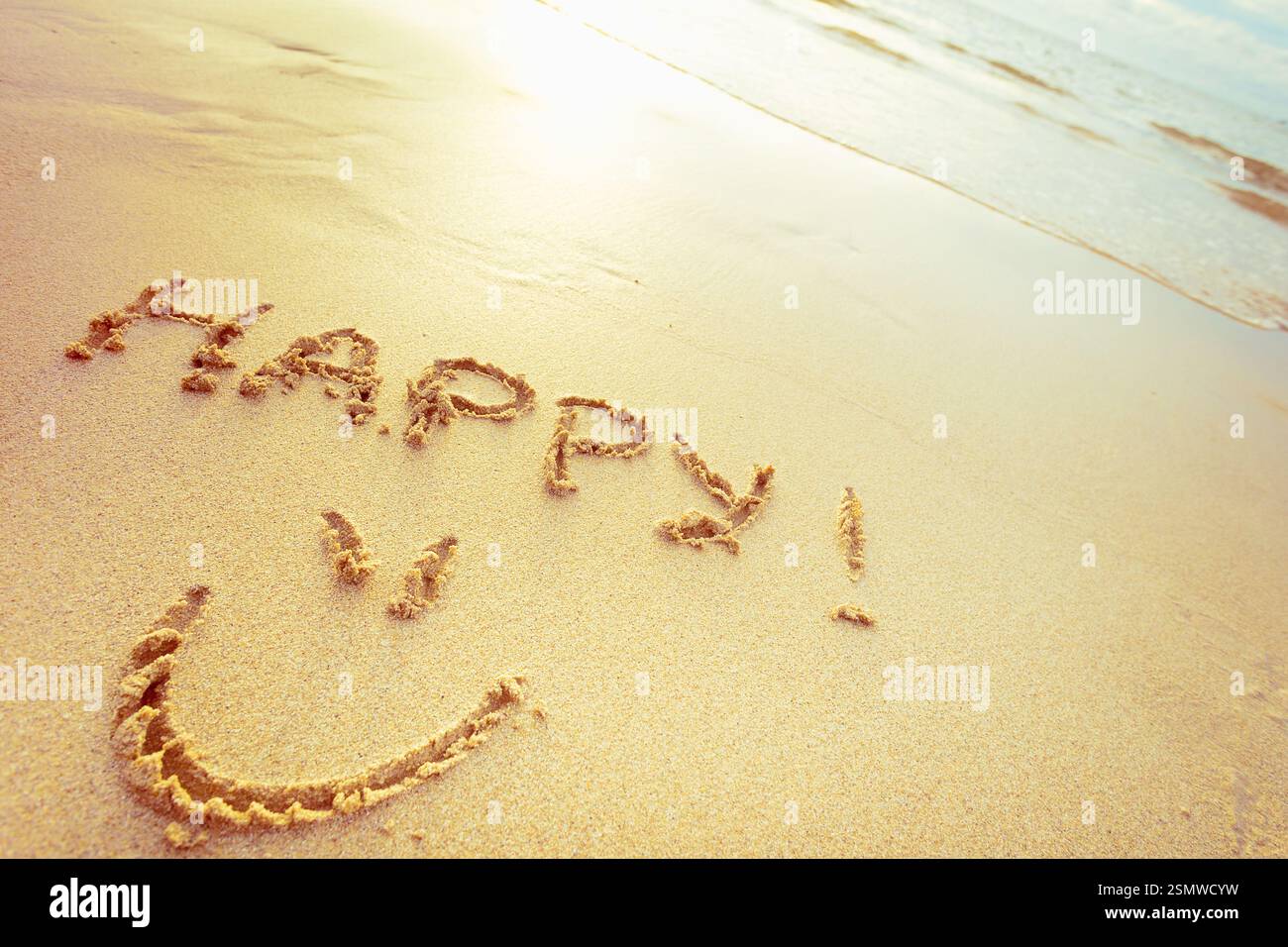Message of happiness written in sand on a sunny beach during daytime ...