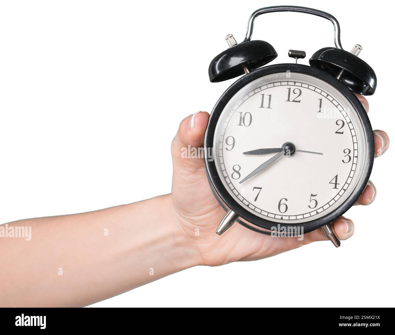 Hand holding a classic black alarm clock showing almost eight in the ...