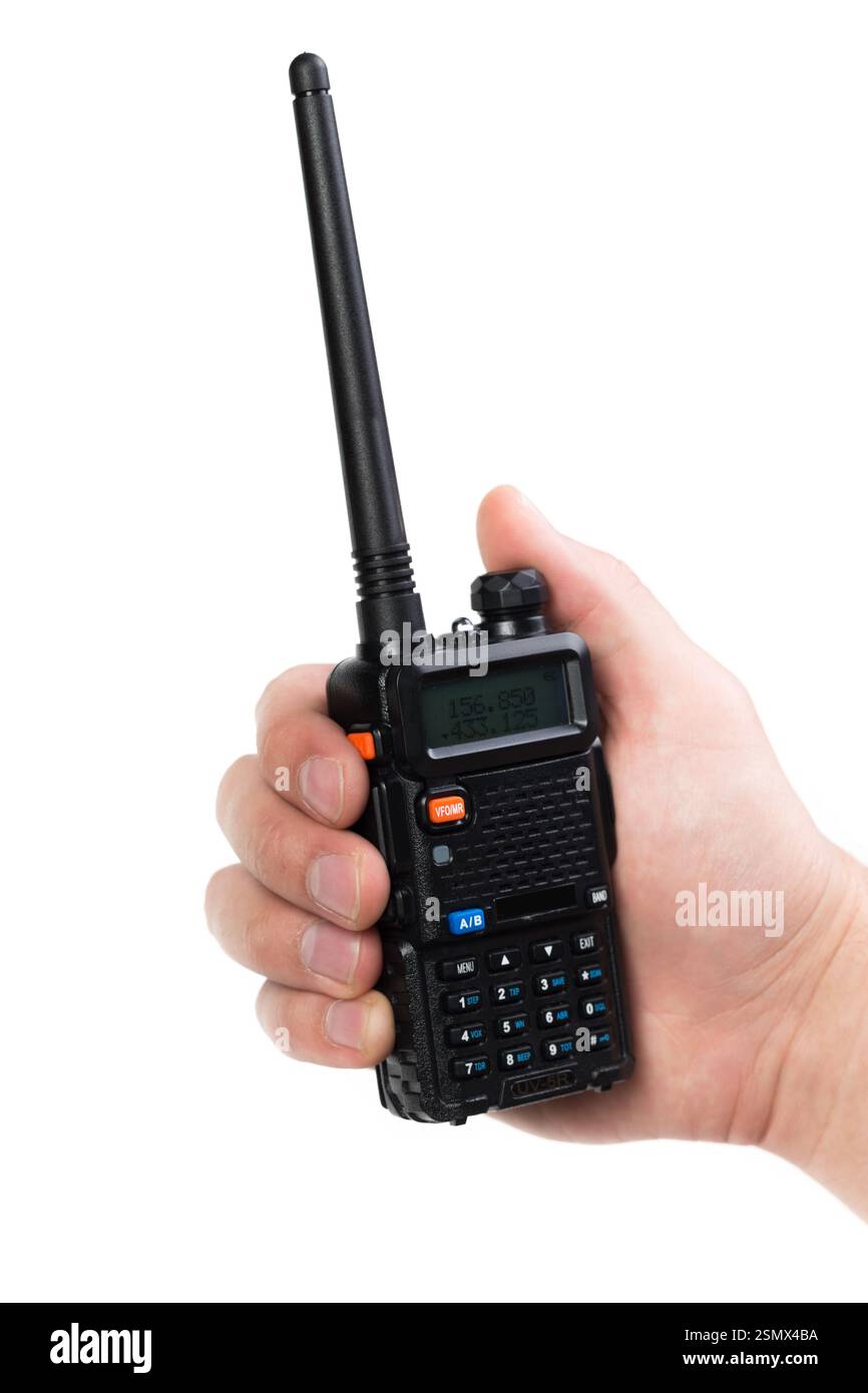 Handheld two-way radio in a person's hand with a visible antenna, ready ...