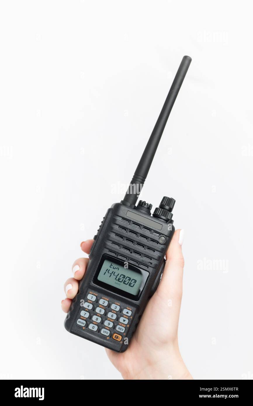 Handheld two-way radio being held with a clear display and antenna ...