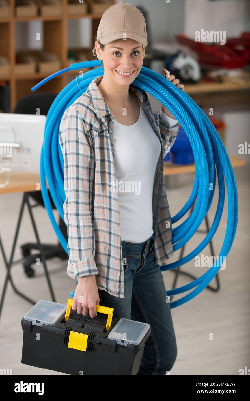 tradeswoman carrying cold water pipe and a toolbox Stock Photo - Alamy