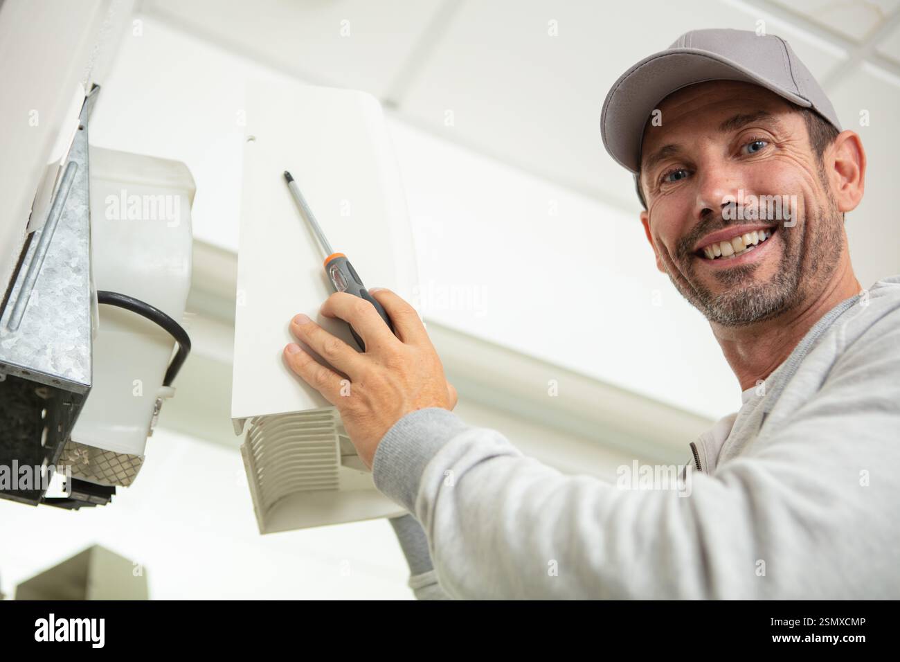 male electrician installing electrical device on wall Stock Photo - Alamy