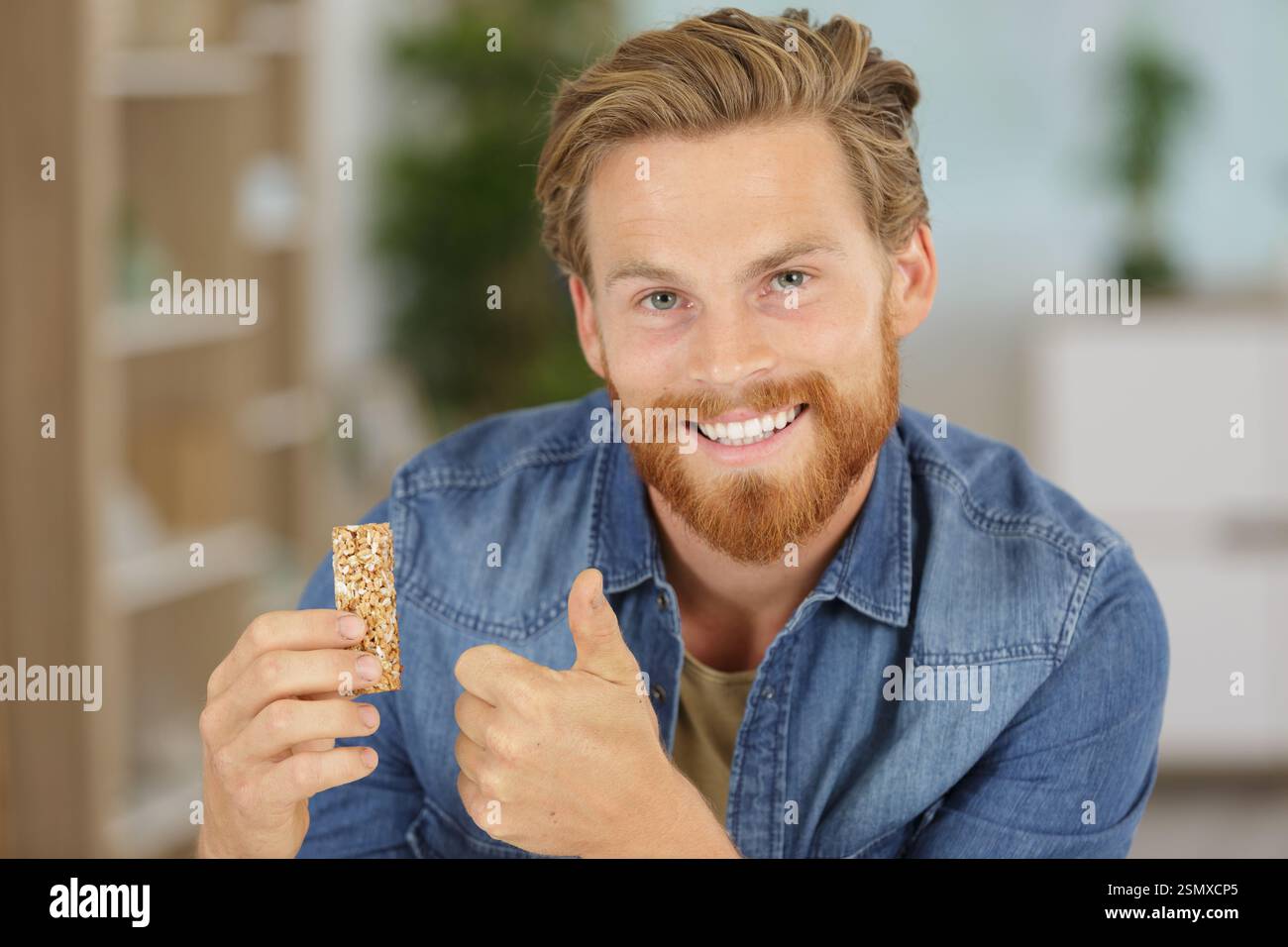 young man eating cereal bar Stock Photo - Alamy