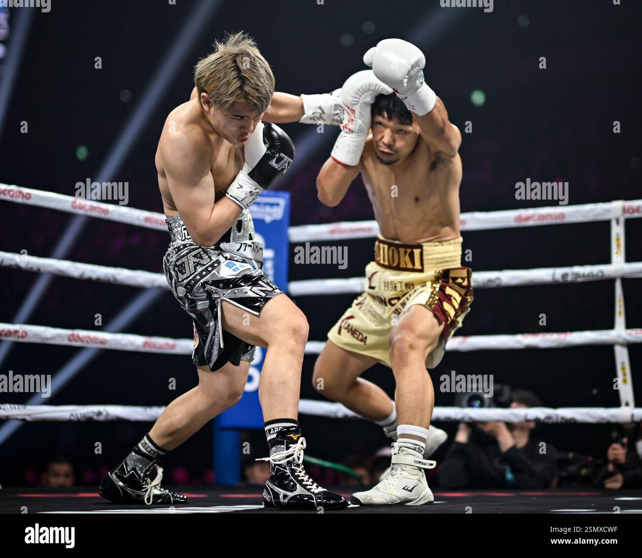 Tokyo, Japan. 24th Jan, 2025. Champion Jin Sasaki (black gloves) hits challenger Shoki Sakai ...