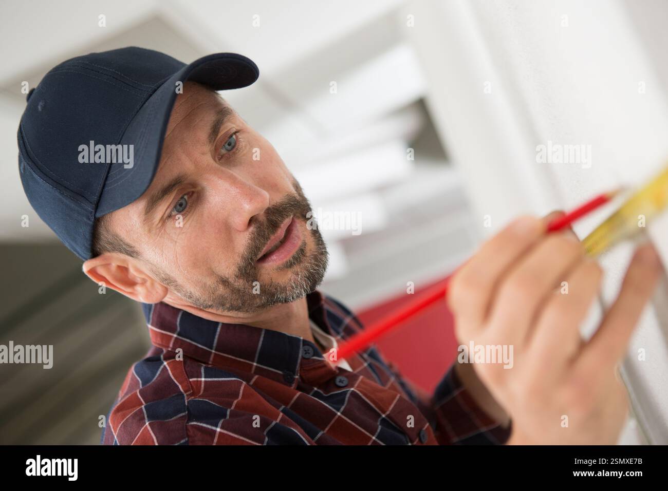 builder marks on the wall with a ruler and pencil Stock Photo - Alamy
