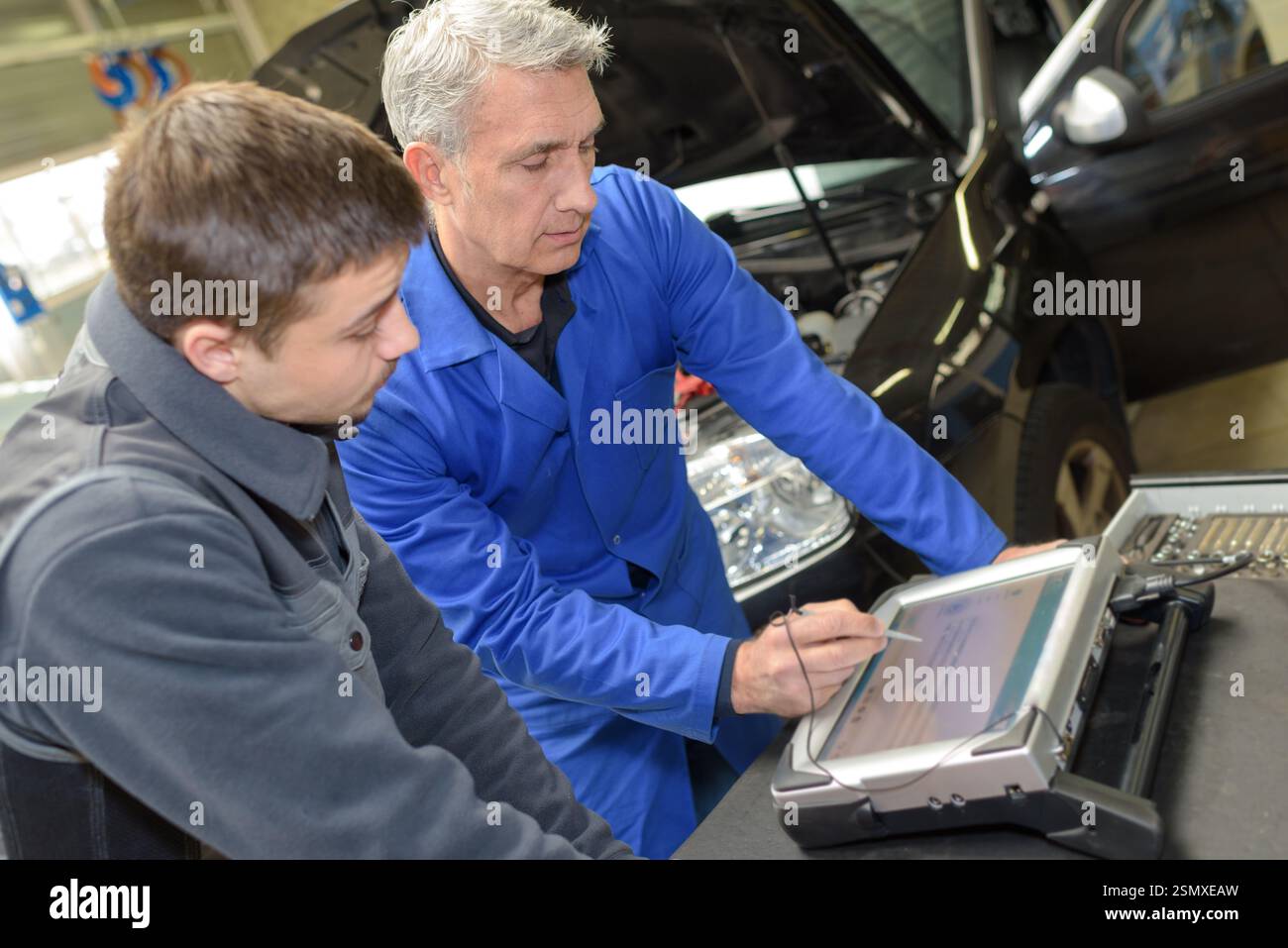 student with instructor repairing a car during apprenticeship Stock ...