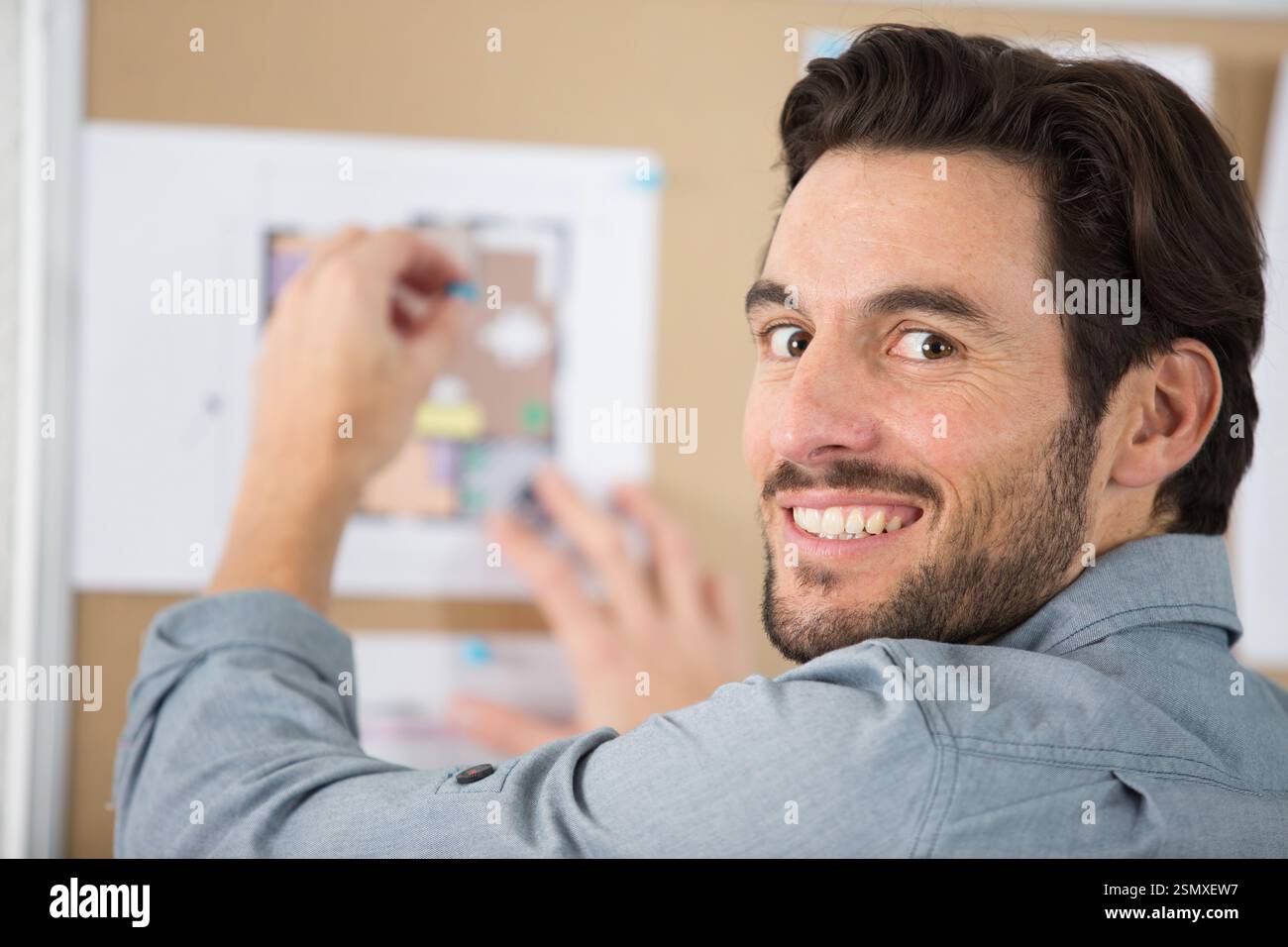 man at notice board looking back over his shoulder Stock Photo - Alamy