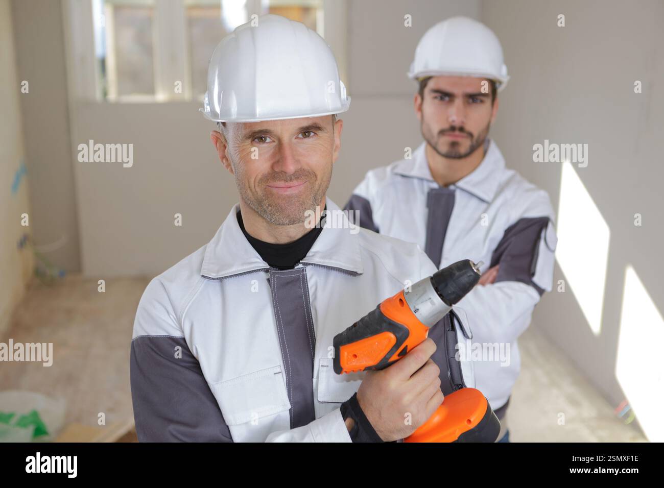 portrait of two male builders in a property under renovation Stock ...