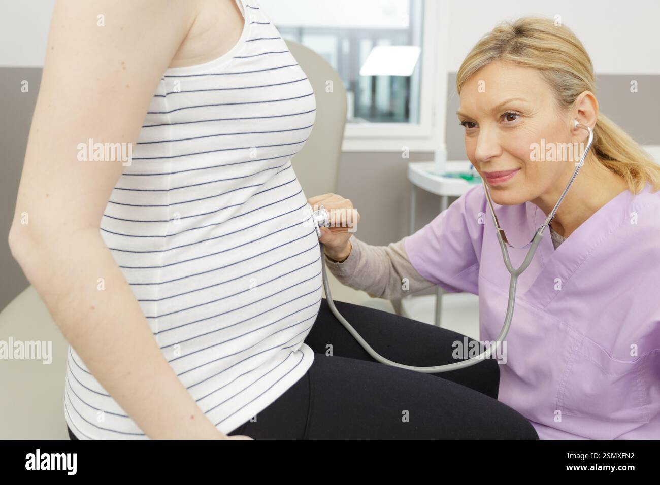 senior female doctor ausculting pregnant woman Stock Photo - Alamy