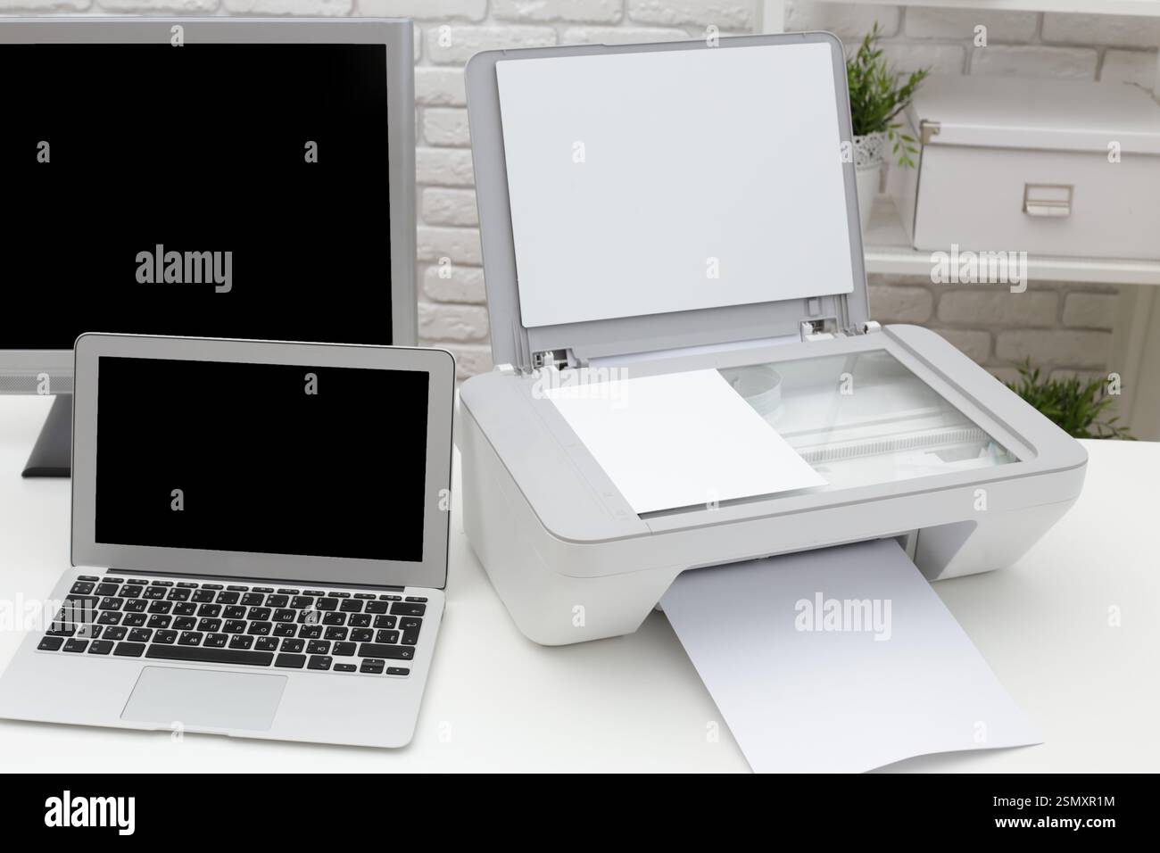 Printer and laptop setup on a modern desk in a cozy workspace during ...