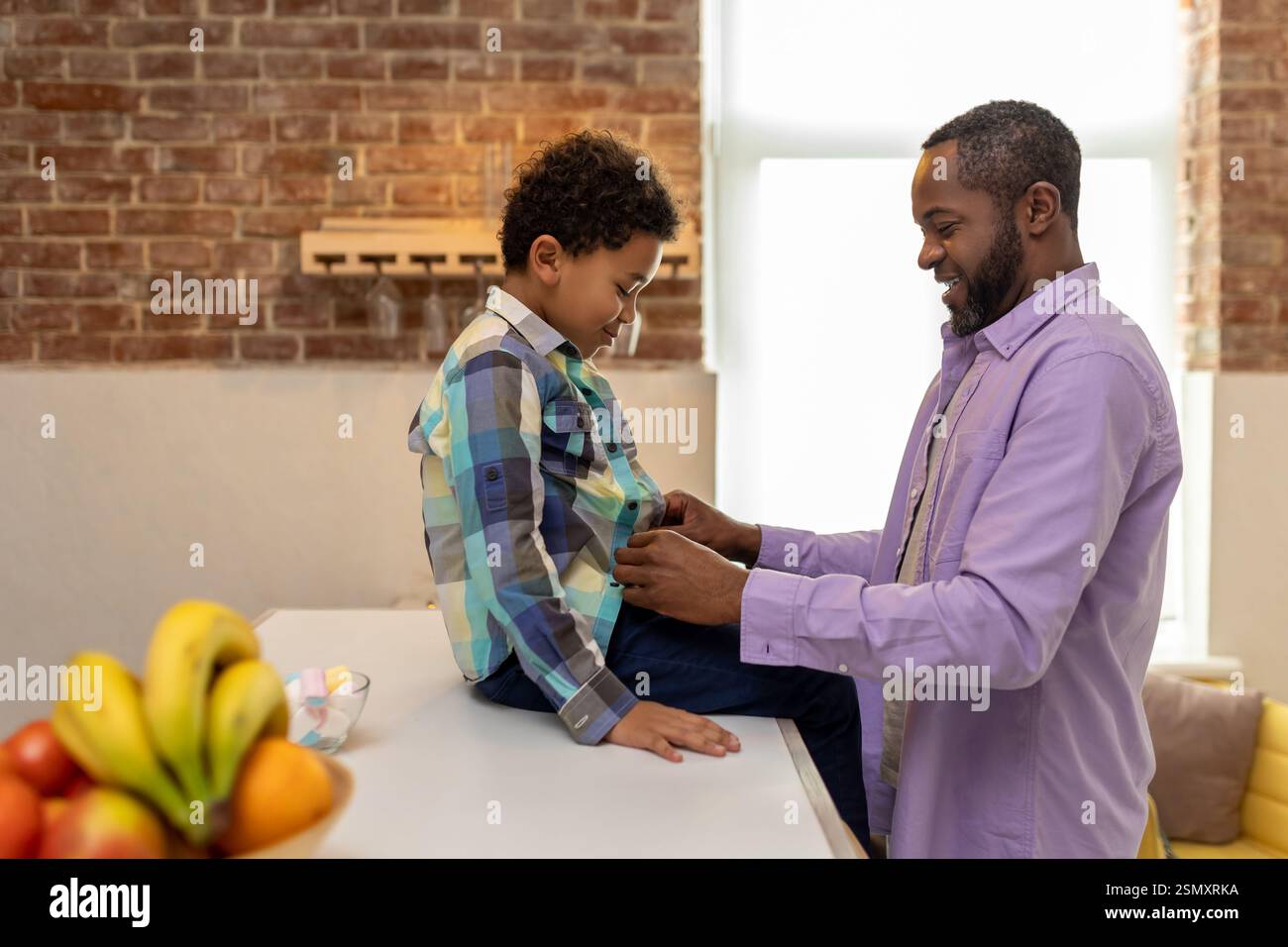 Getting dressed. Father and son at home getting dressed in the kitchen ...