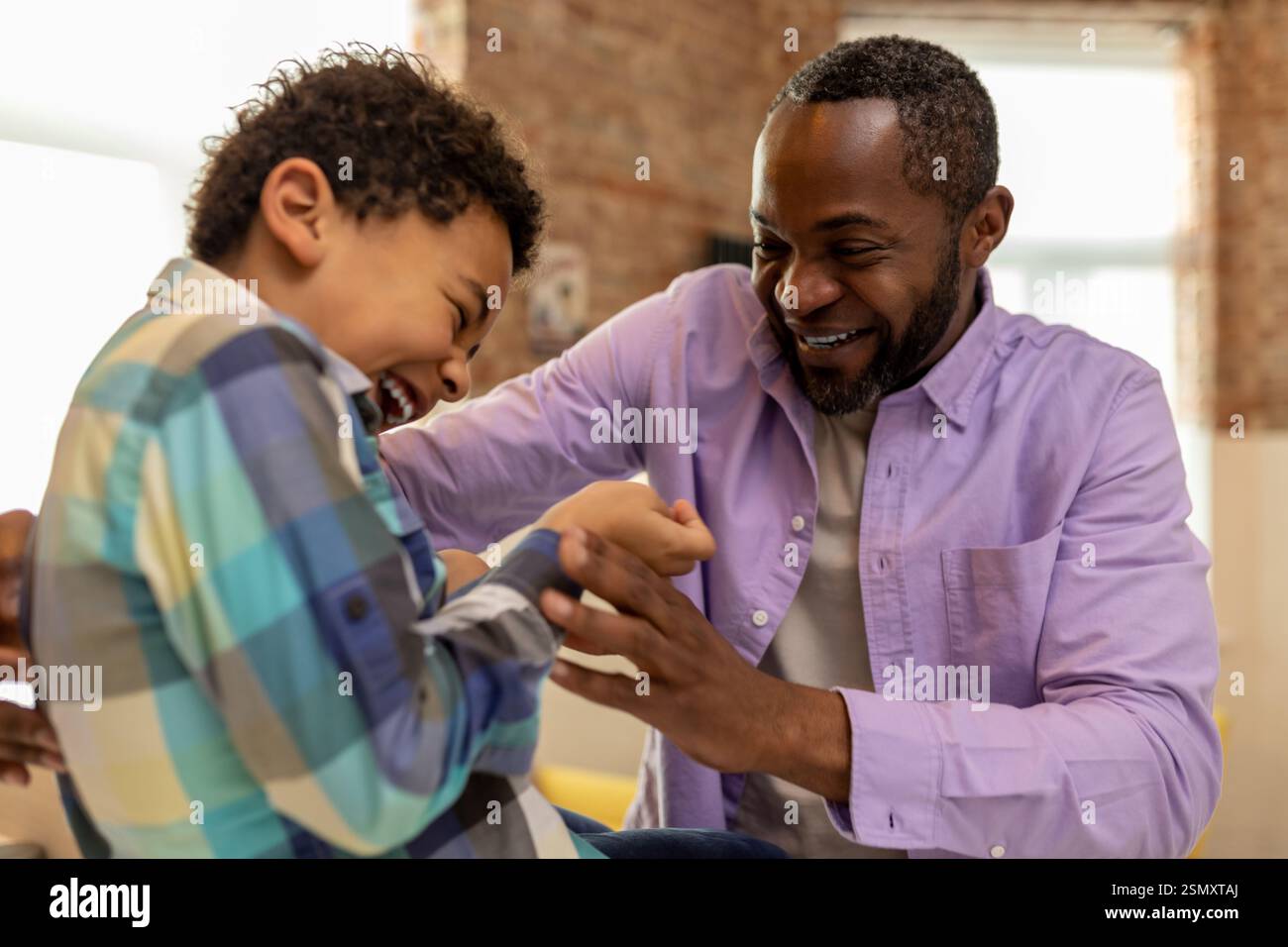 Father and son at home getting dressed in the kitchen and looking ...