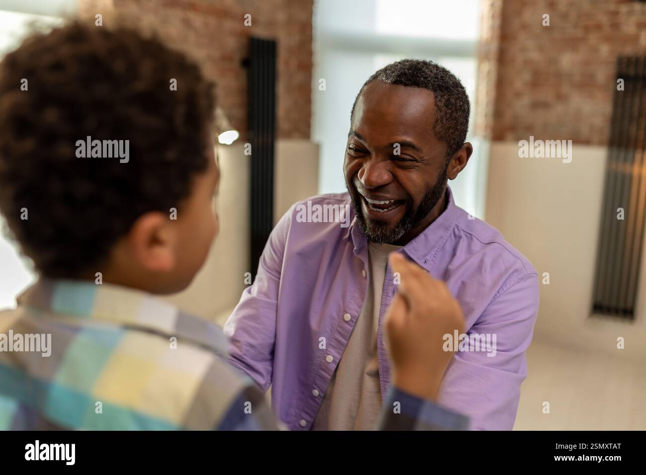 Father and son at home getting dressed in the kitchen and looking ...