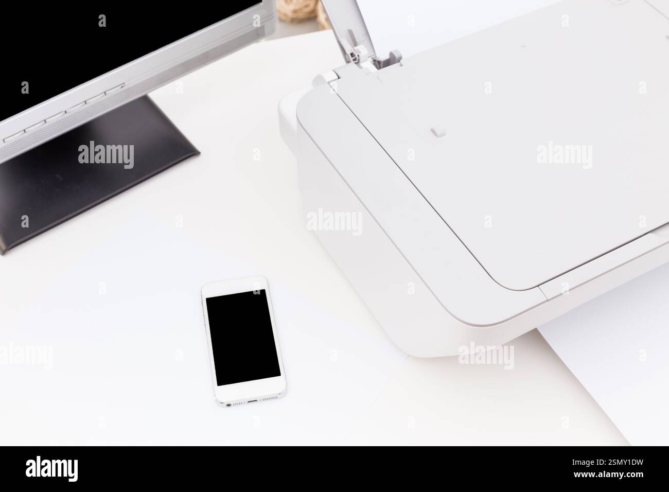 Home office setup featuring a printer, computer monitor, and smartphone ...