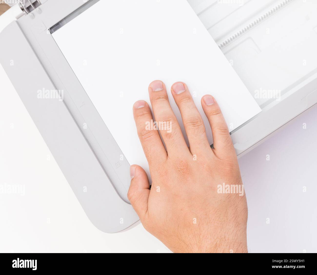 Hand placing paper into a scanner for digital documentation in a bright ...