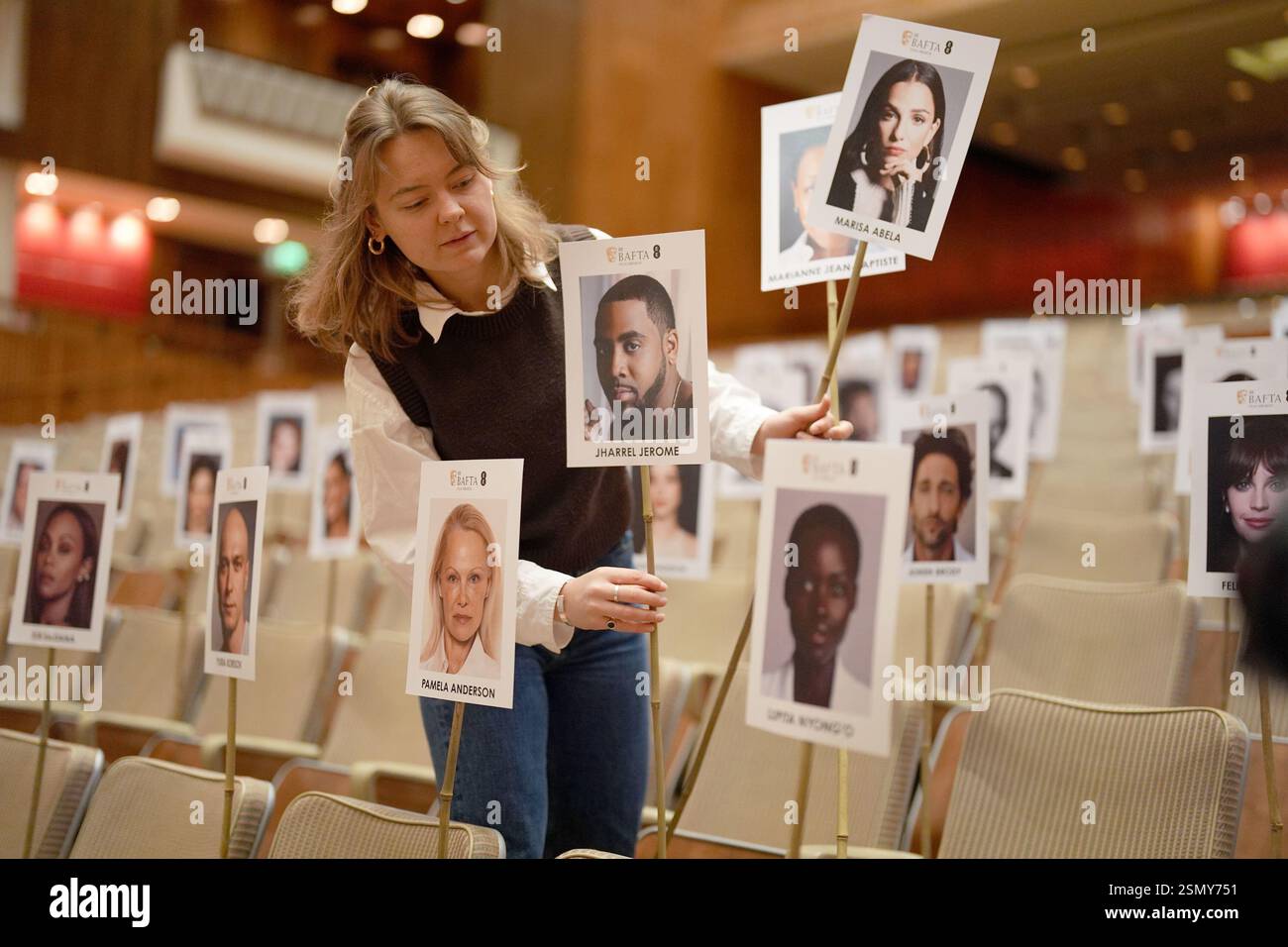 A staff member uses "heads on sticks" to check camera blocking at the ...