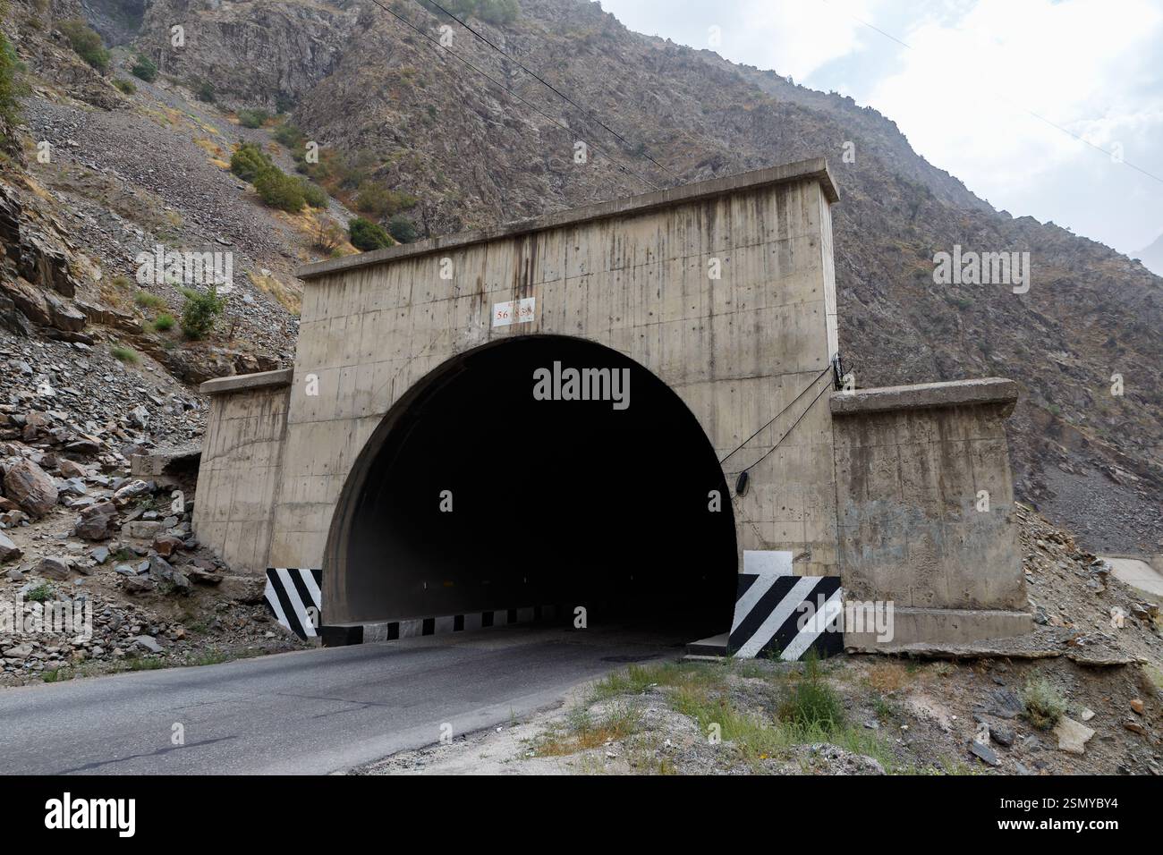 The concrete tunnel entrance on M34 highway is framed by steep mountain ...