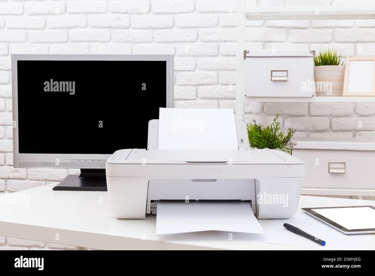 Home office setup with a printer, computer monitor, and organization ...
