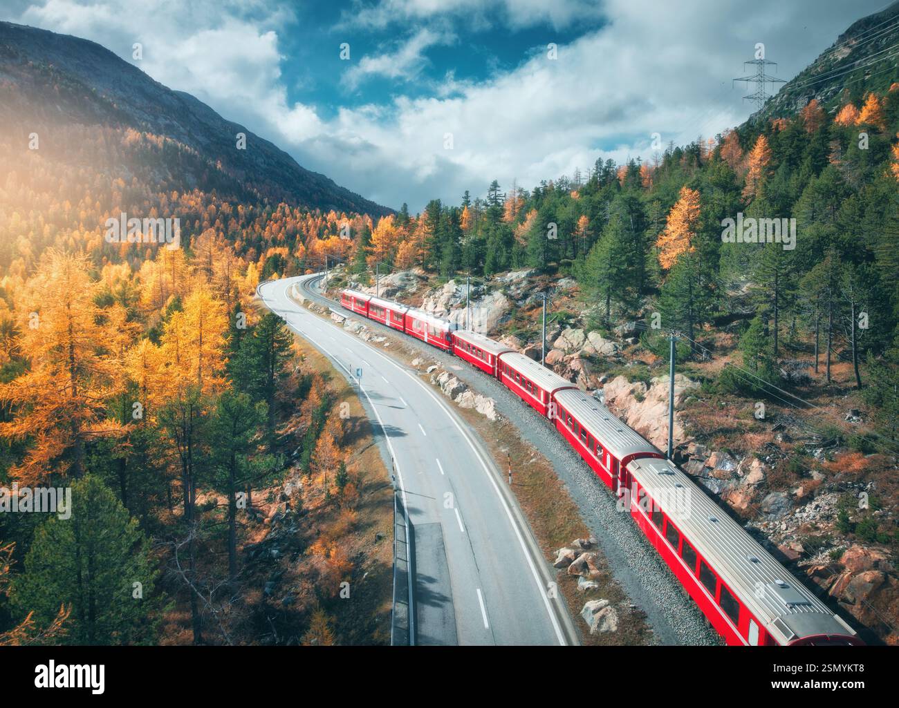 Aerial view of red train, river in mountains, road, orange forest Stock ...
