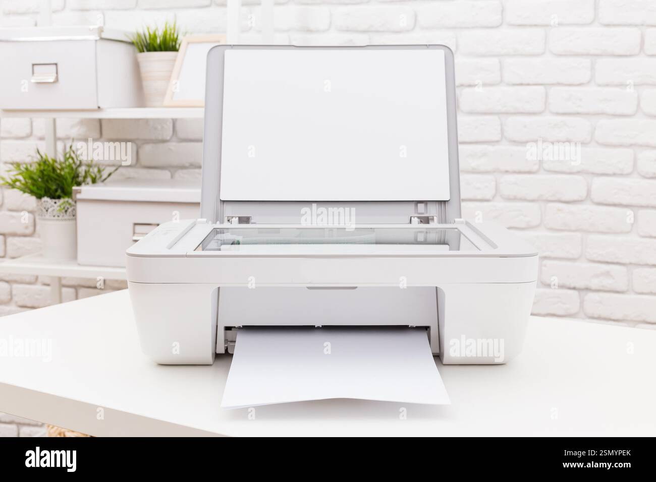 Printer situated on a desk printing a blank document in a bright and ...