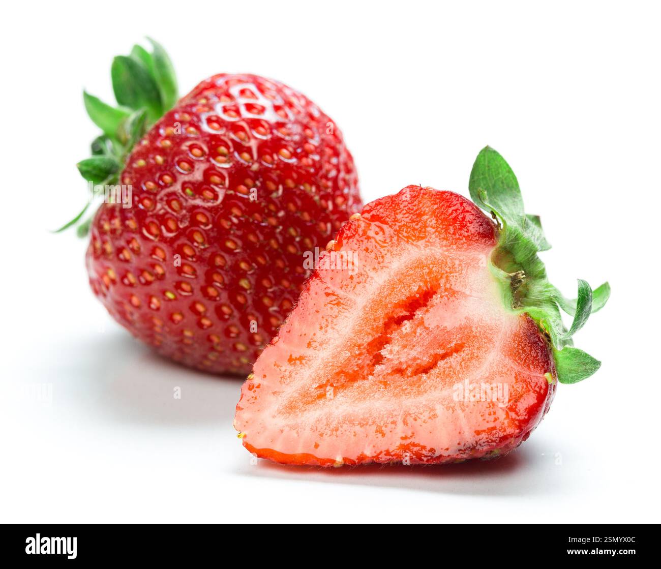 Fresh strawberries displayed with one cut in half to reveal juicy ...