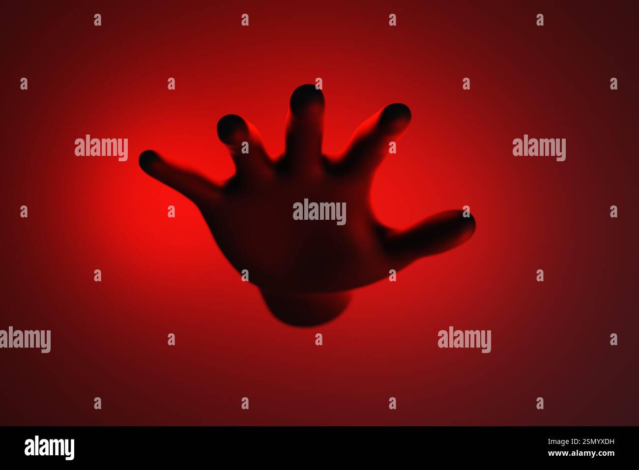 Out of focus black hand approaching the screen in dark red background ...